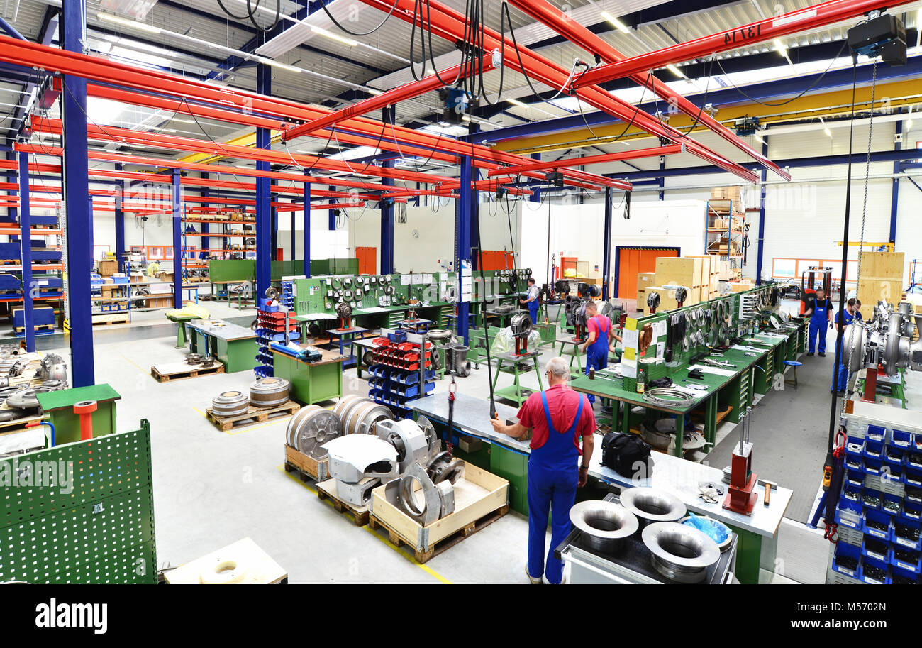 workers in a factory for the assembly of compressors in mechanical ...