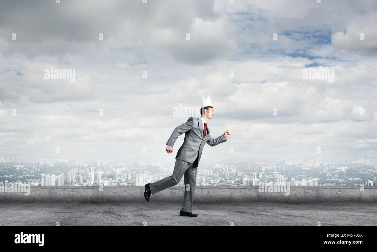 King businessman in elegant suit running on building roof and business ...