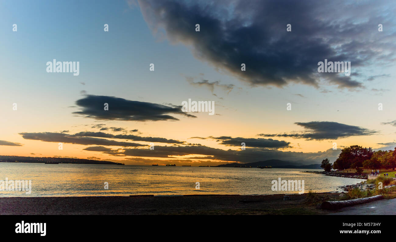 View of the evening ocean with lights of ships, mountains and clouds ...