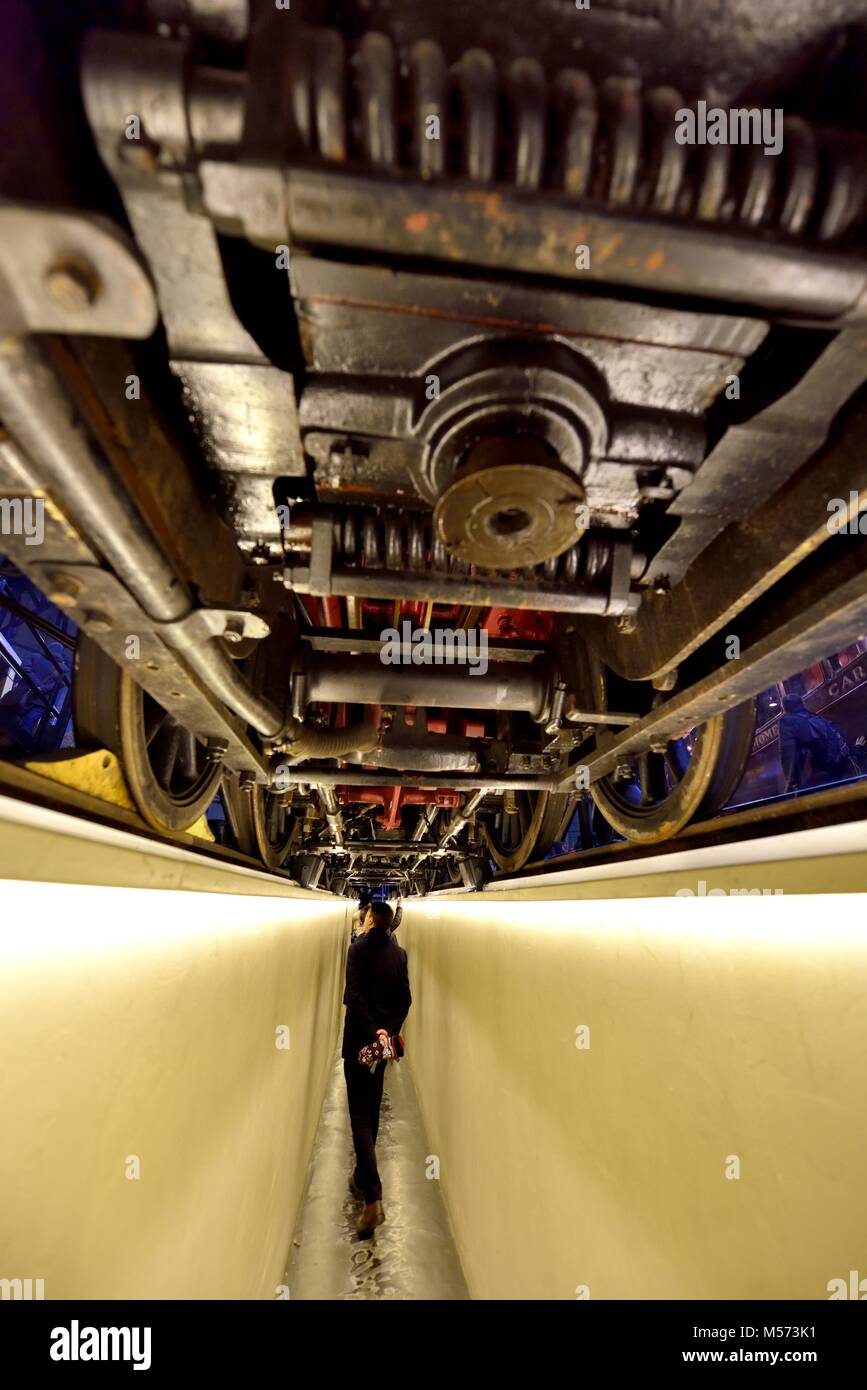 People walking underneath an old steam locomotive in the National ...