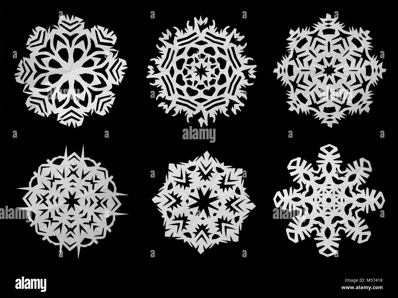 Snowflakes cut out of white paper on a black background Stock Photo - Alamy