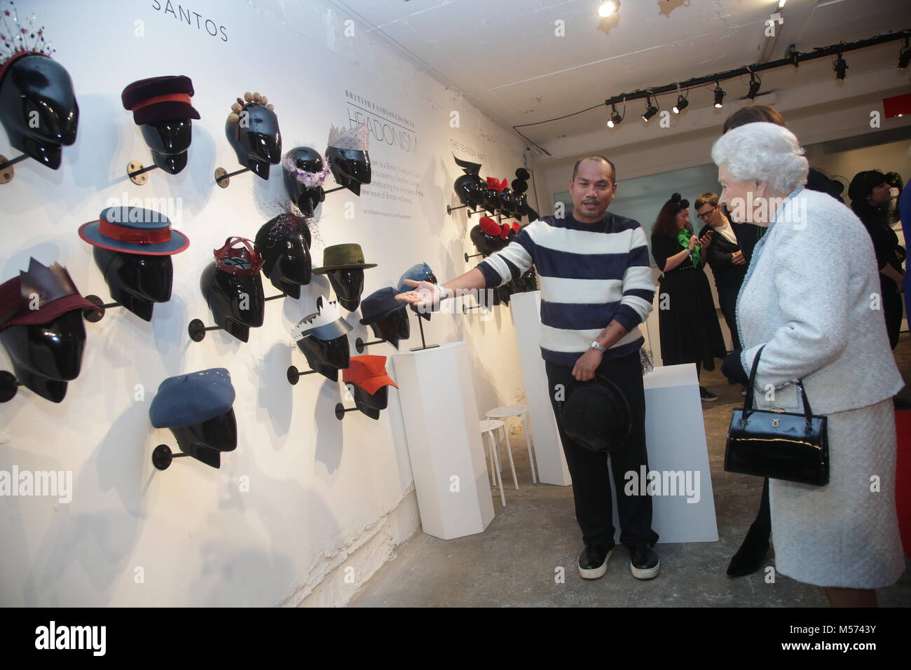 Queen Elizabeth II talks to milliner Harvy Santos as she visits London ...