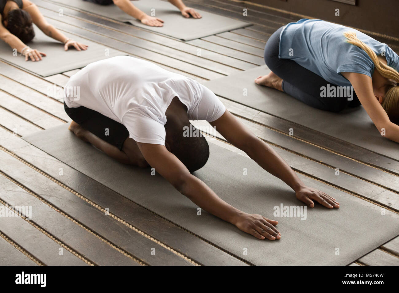 Group of young people in Child pose Stock Photo - Alamy