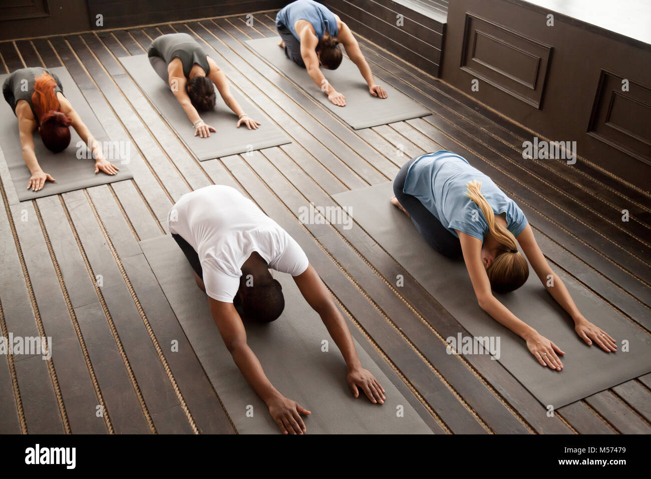 Group of young people in Child pose, top view Stock Photo - Alamy