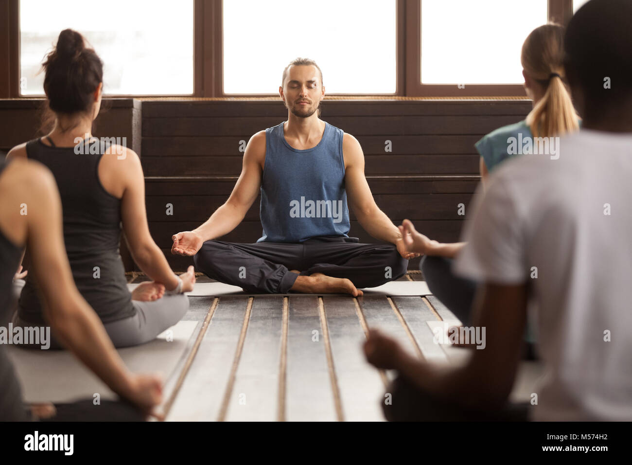 Group of young sporty people in Easy Seat pose Stock Photo - Alamy