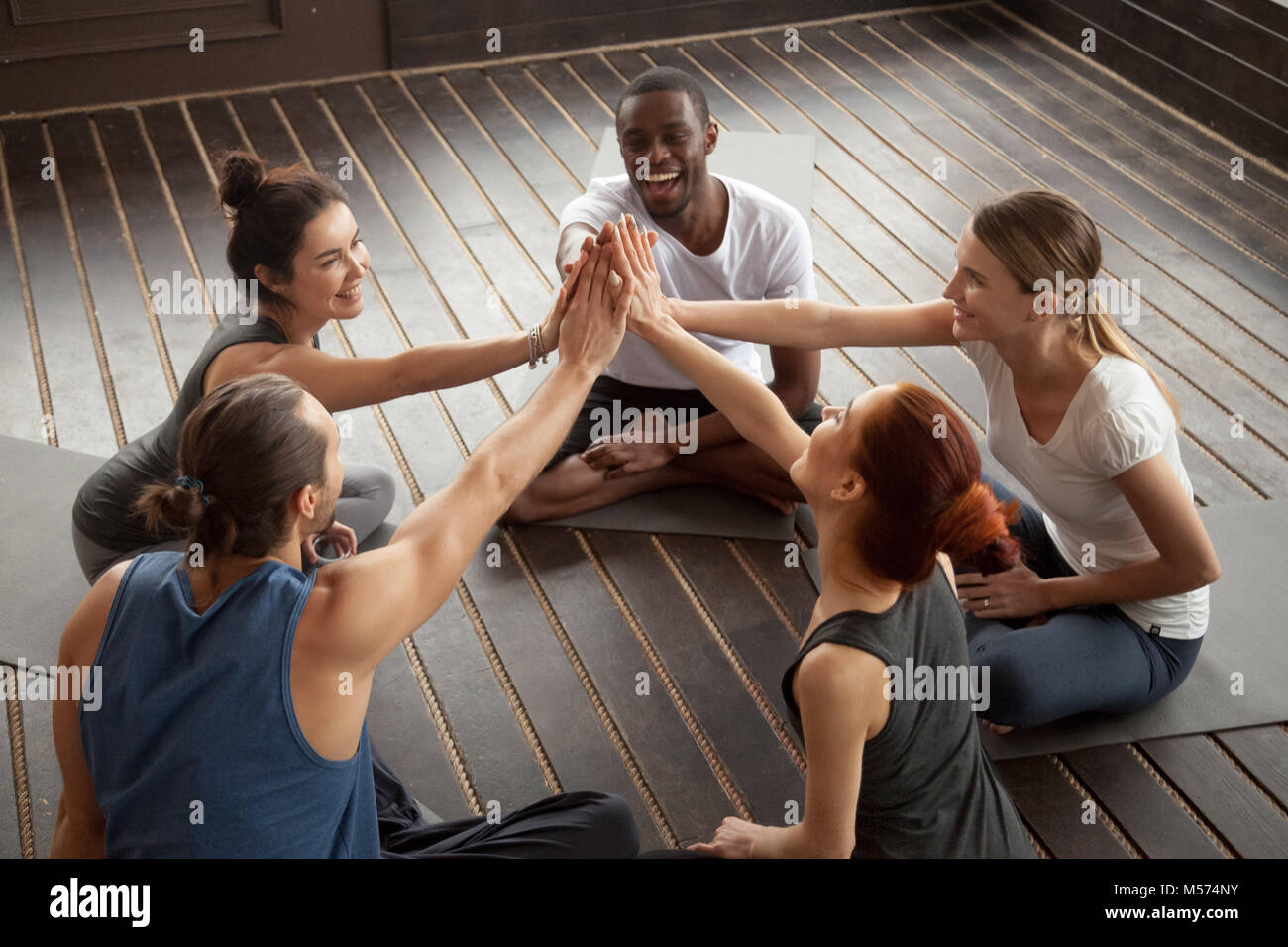 Diverse happy people giving high five at group training Stock Photo - Alamy