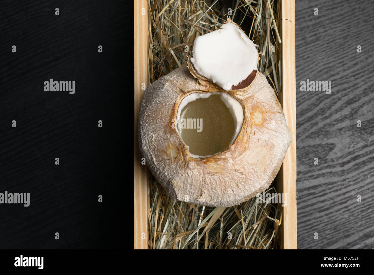 coconut with coco milk in the hay Stock Photo - Alamy