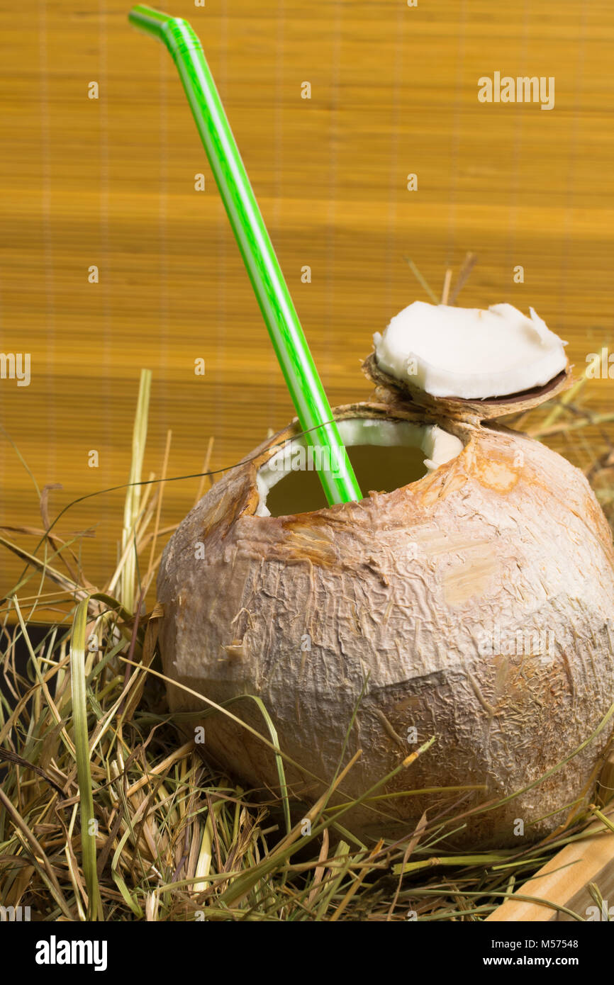 coconut with coco milk in the hay Stock Photo - Alamy