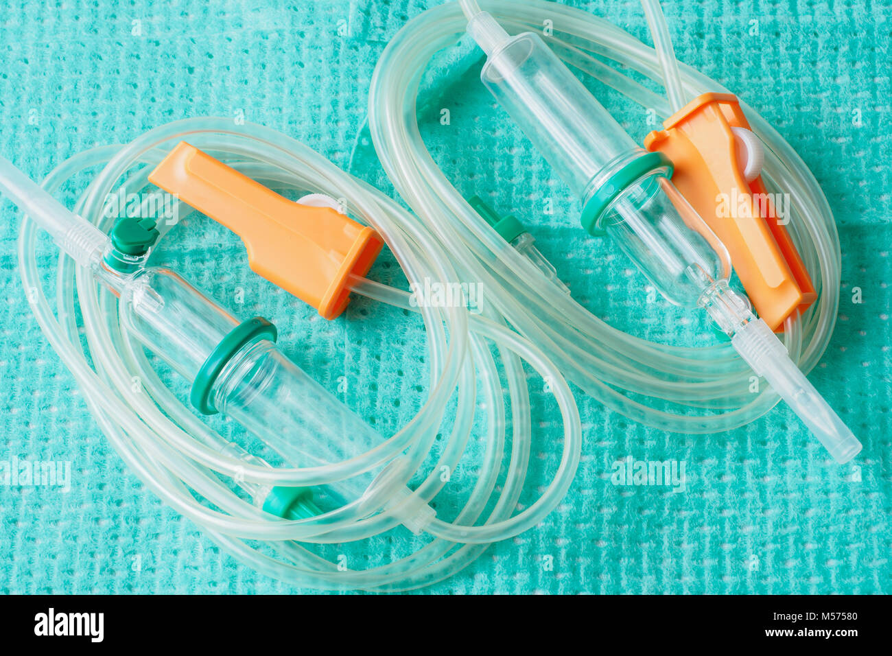 Disposable infusion set on green background Stock Photo - Alamy