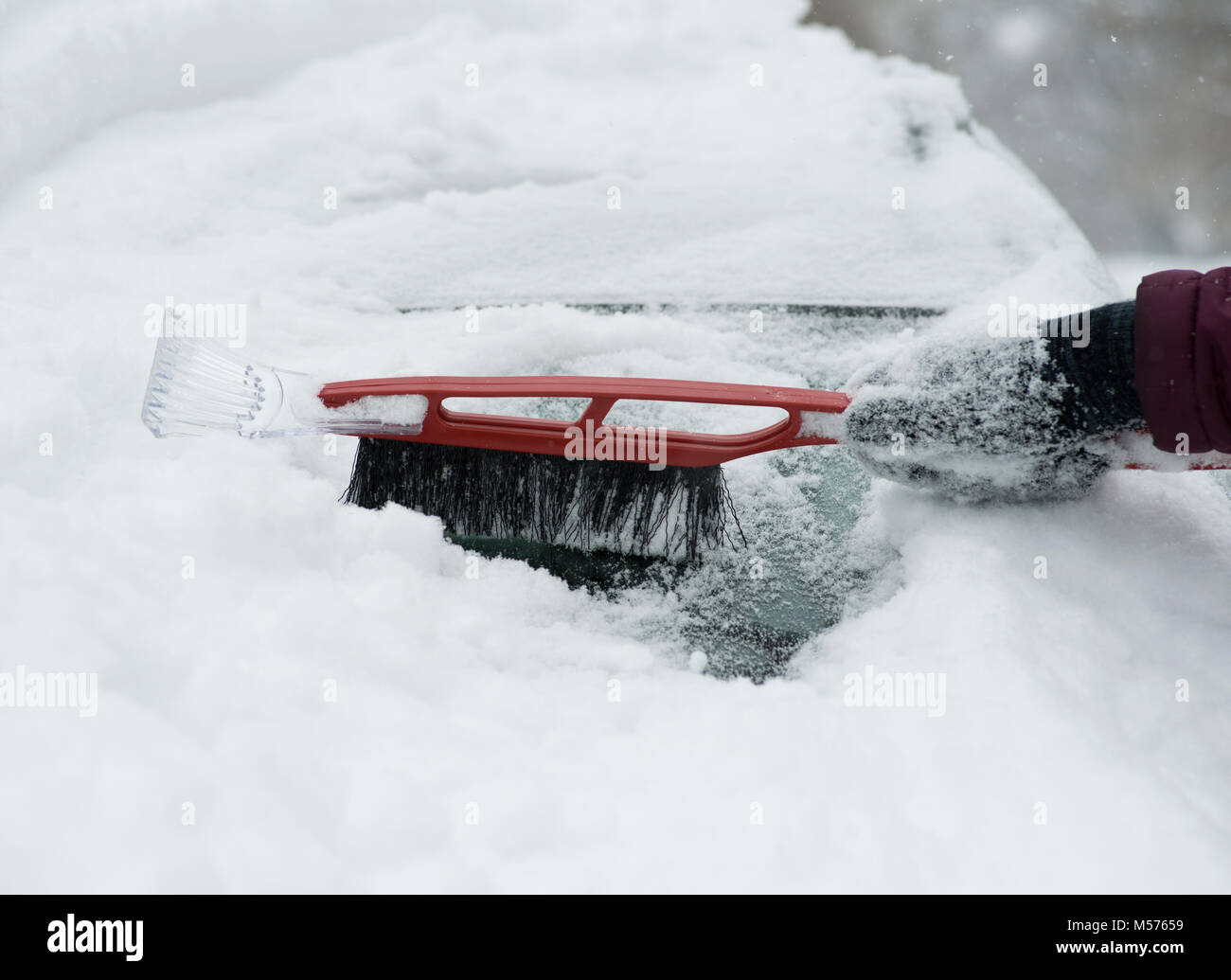 Young woman is sweeping off snow from her car Stock Photo - Alamy