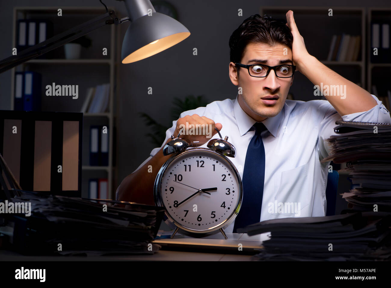 Young businessman working overtime late in office Stock Photo - Alamy