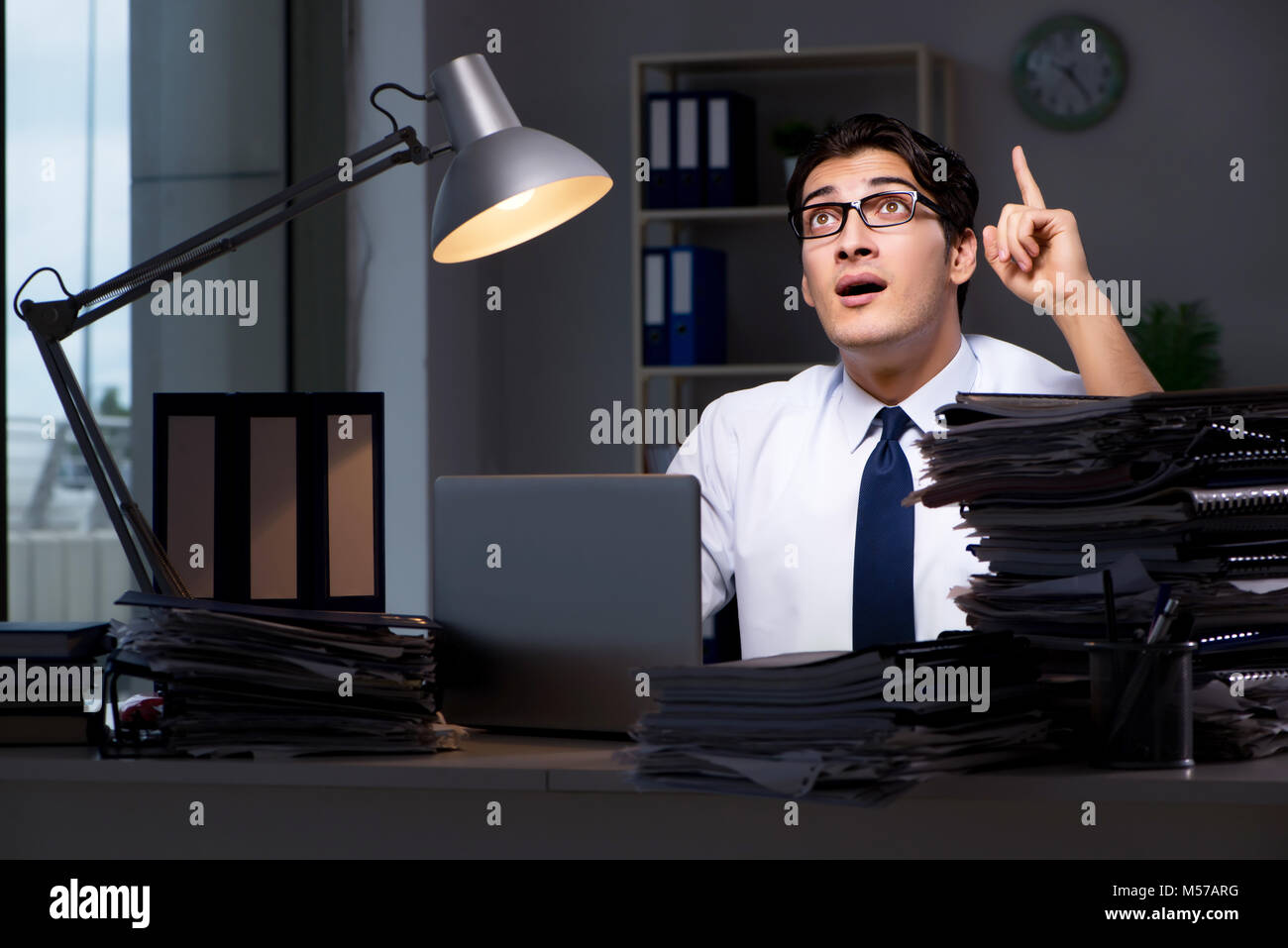 Young businessman working overtime late in office Stock Photo - Alamy