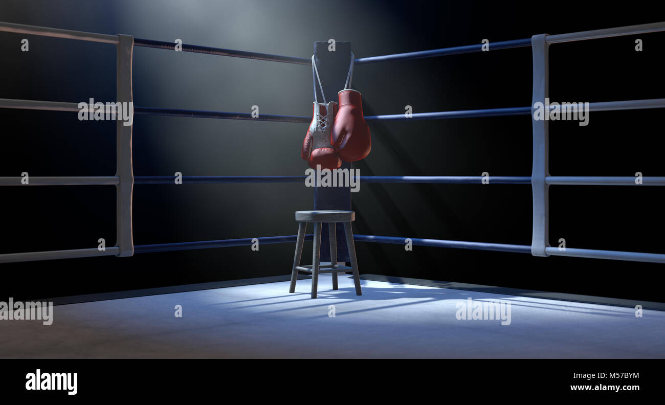 The blue corner of a boxing ring with gloves hanging on a pole spotlit ...