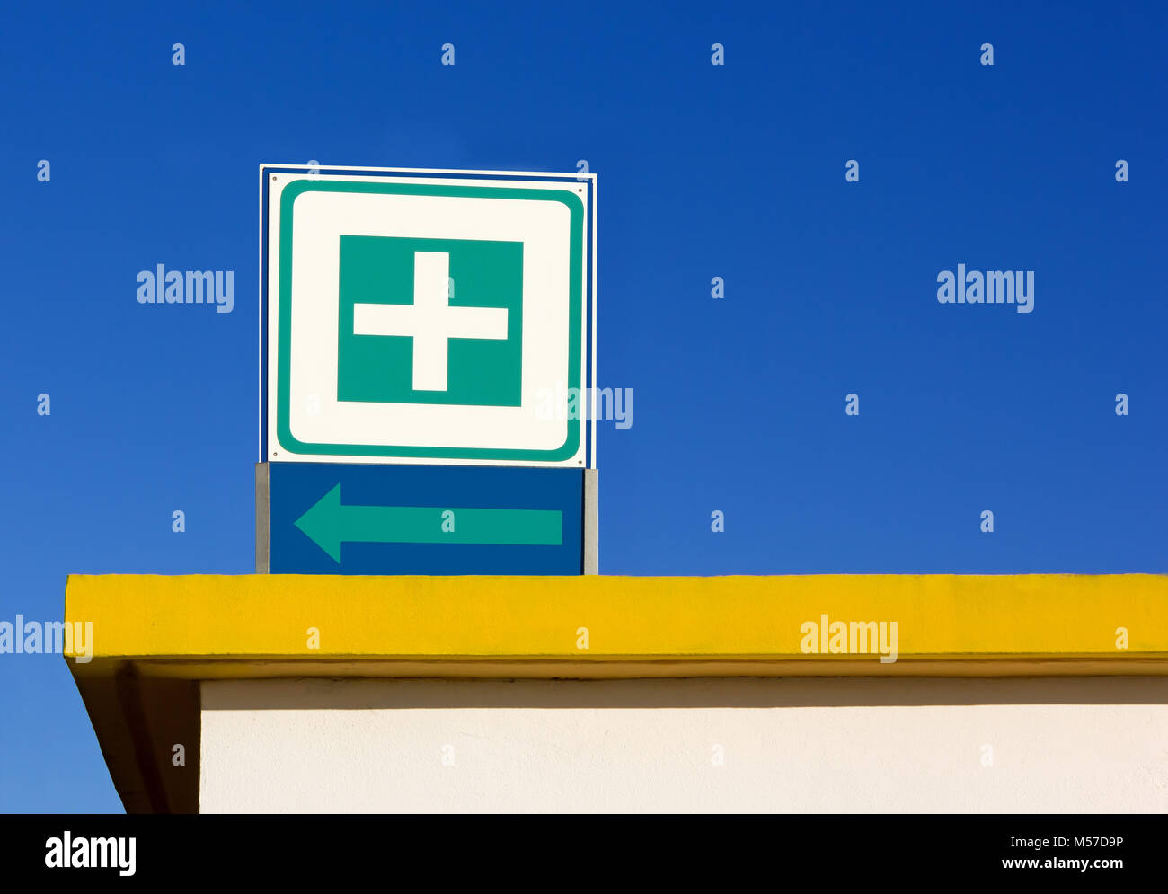 Infirmary symbol sign over a yellow colored roof Stock Photo - Alamy
