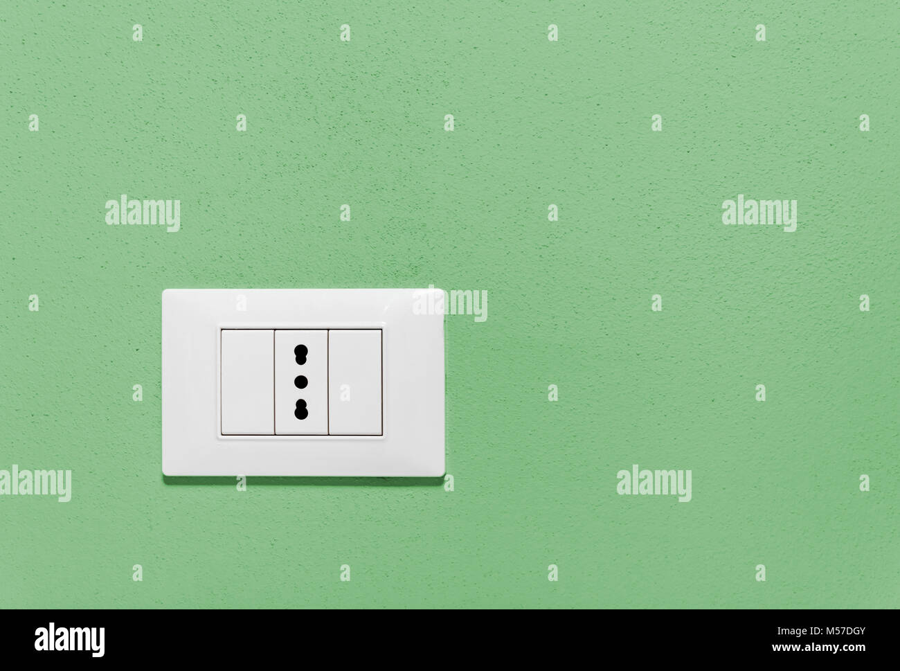 Empty wall socket on a green interior wall Stock Photo - Alamy