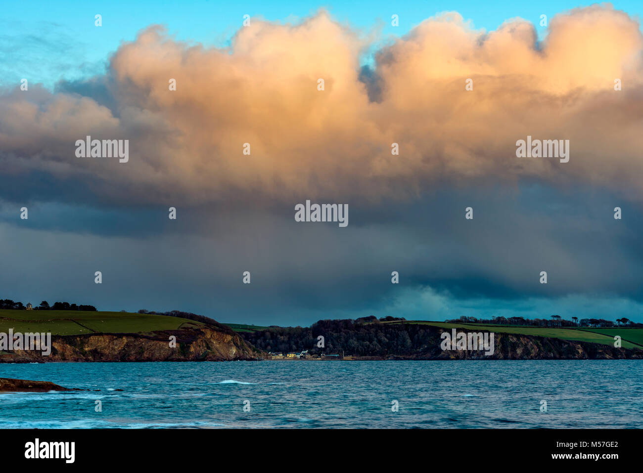Large rain clouds dwarf the tiny coastal town of Polkerris in Cornwall ...