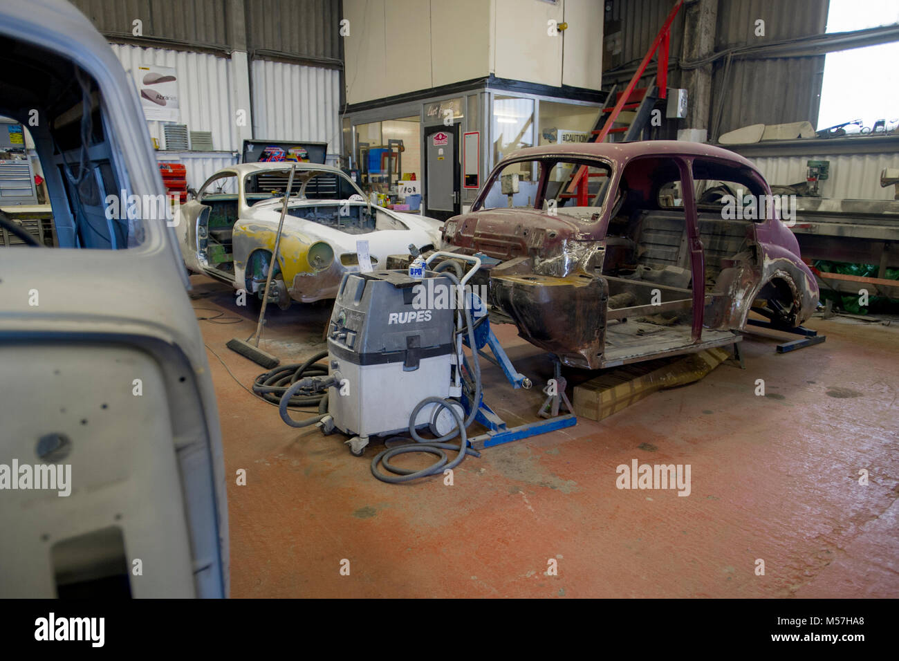 Classic car workshop filled with projects Stock Photo - Alamy