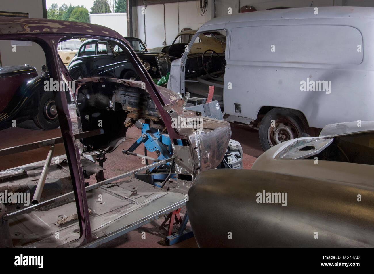 Classic car workshop filled with projects Stock Photo - Alamy