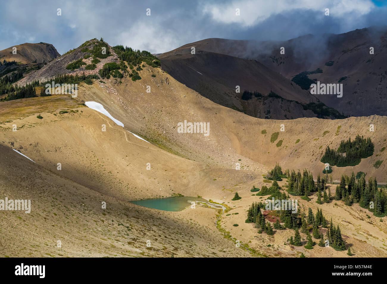 Turquoise-colored tarn perched high in an alpine area along the Grand ...