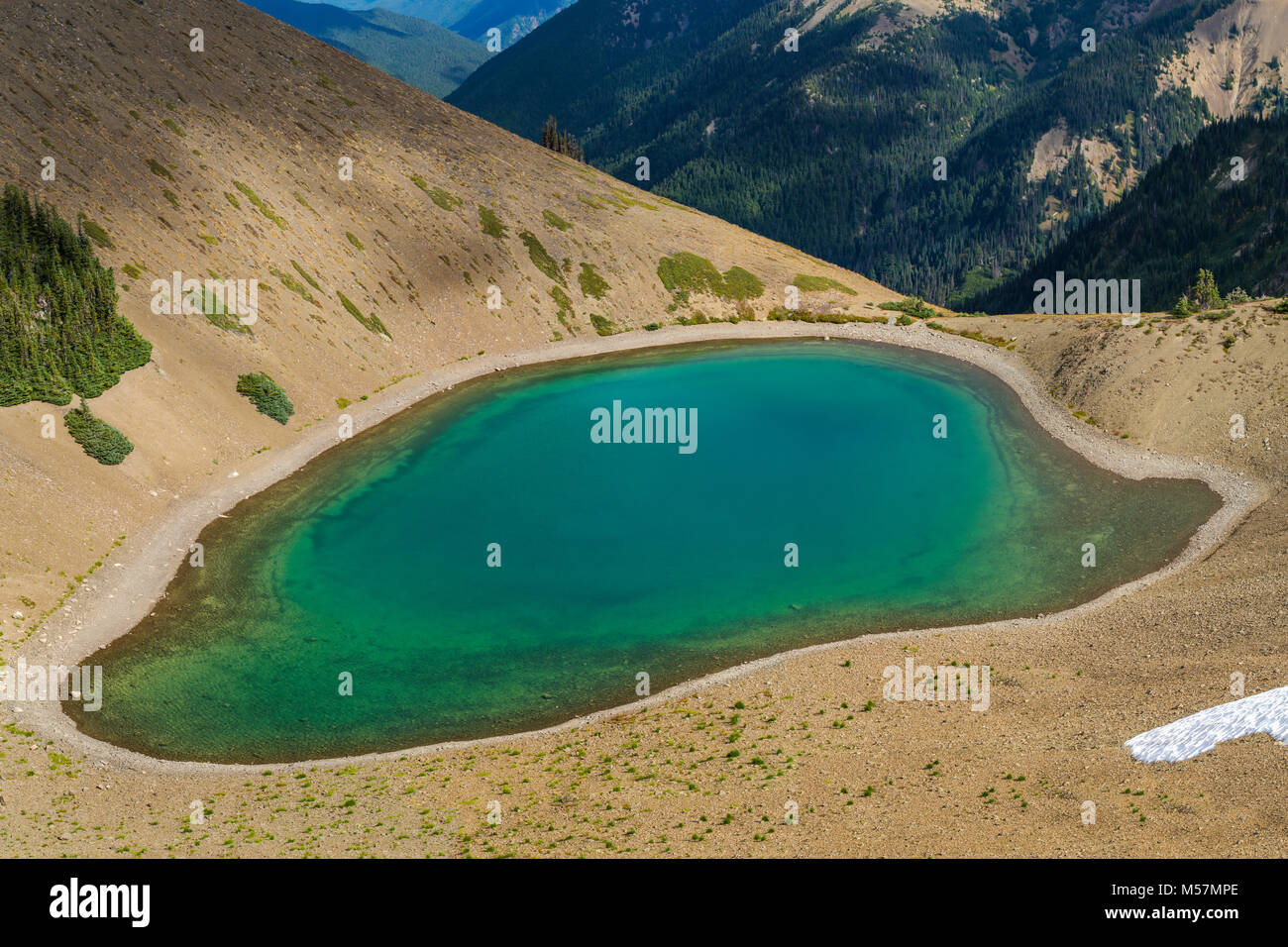 Turquoise-colored tarn perched high in an alpine area along the Grand ...
