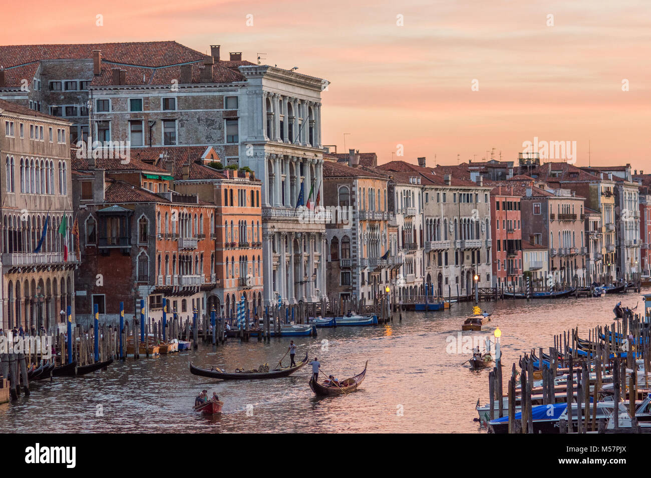 the Grande canal in Venice under the sunset with venetian gondolas ...