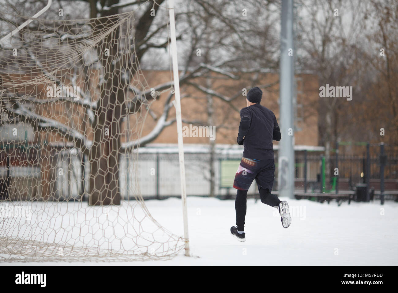 Image from back of running athlete near gate in stadium Stock Photo - Alamy