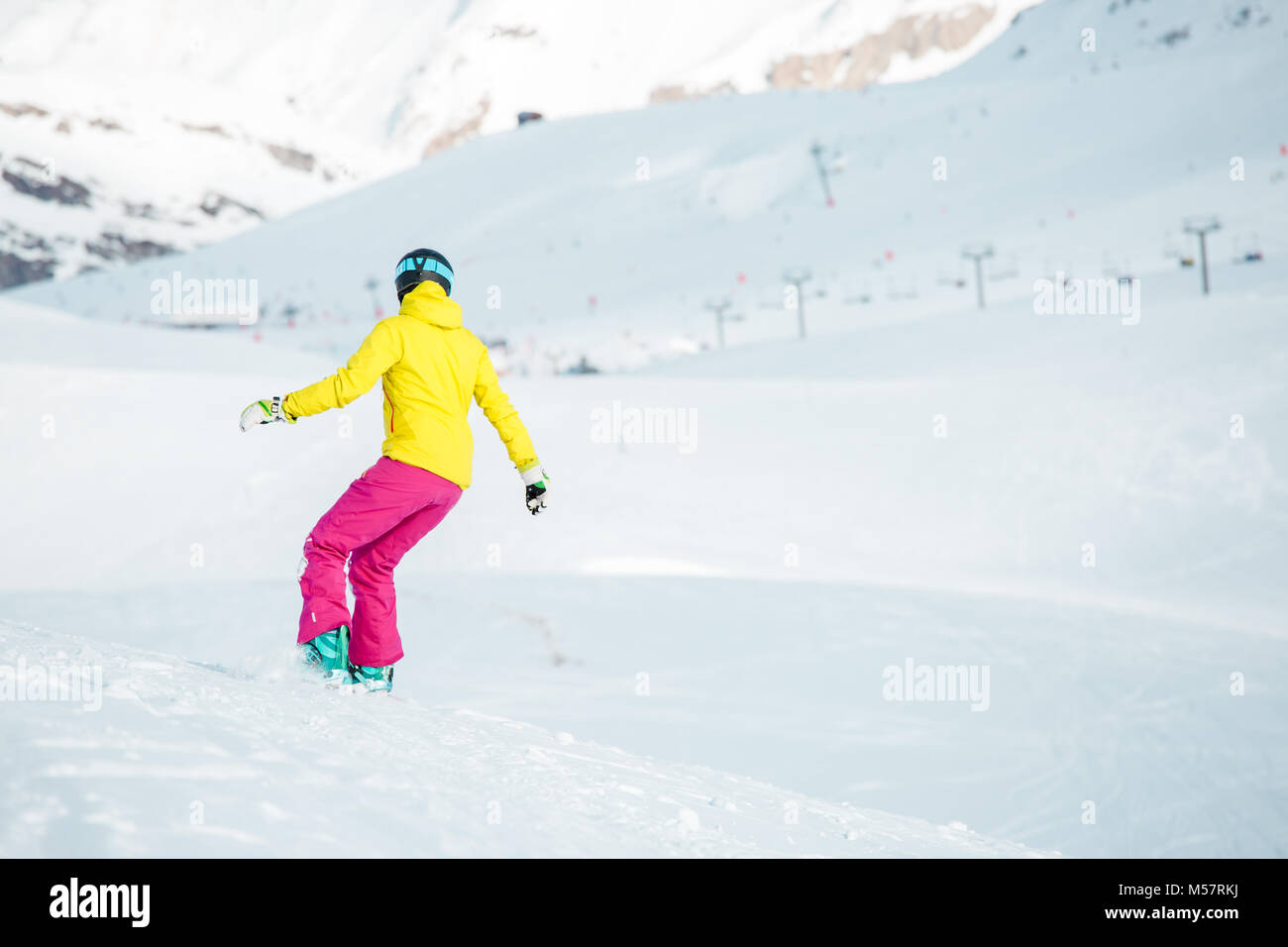 Image from back of girl in sports clothes snowboarding Stock Photo - Alamy