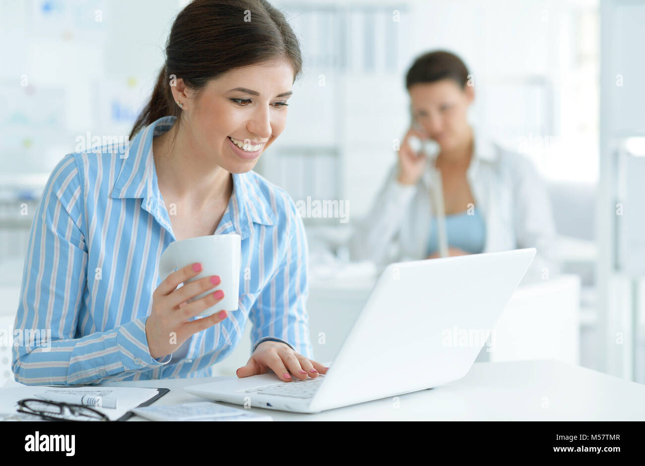Young attractive woman working in office Stock Photo - Alamy