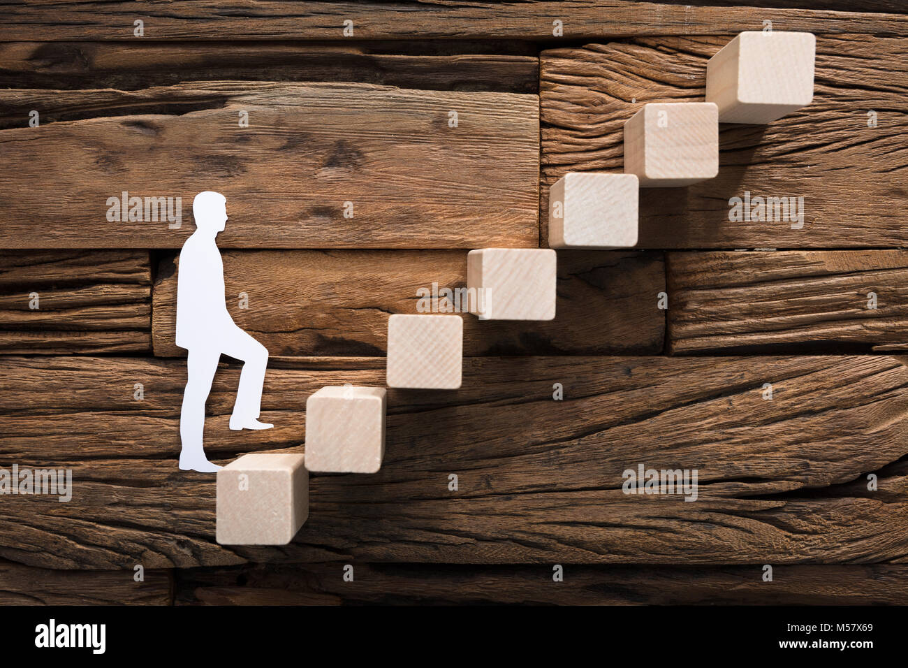 Closeup of paper businessman climbing block ladder on wood Stock Photo ...