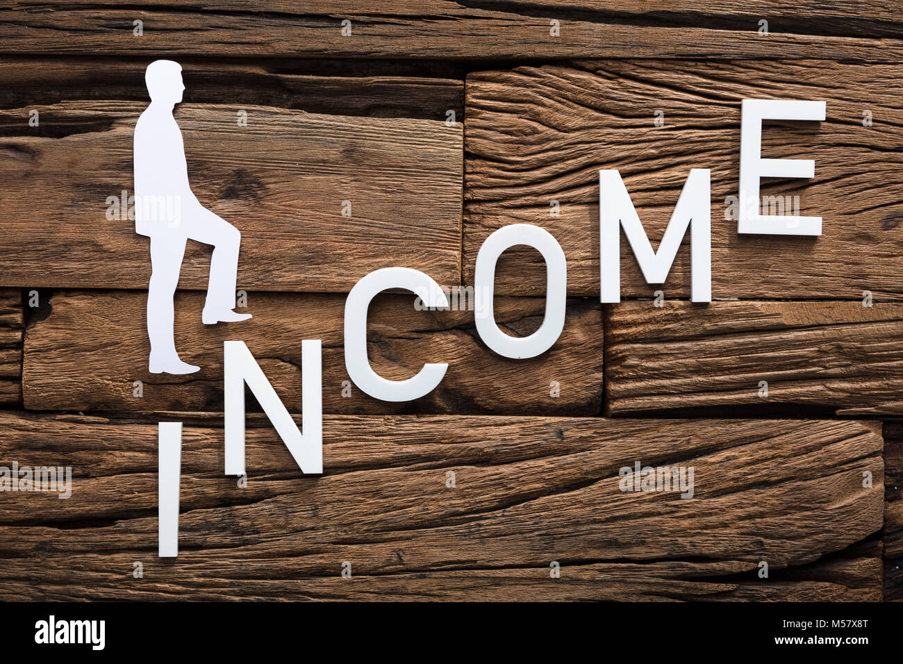 Closeup of paper businessman climbing income ladder on wood Stock Photo ...