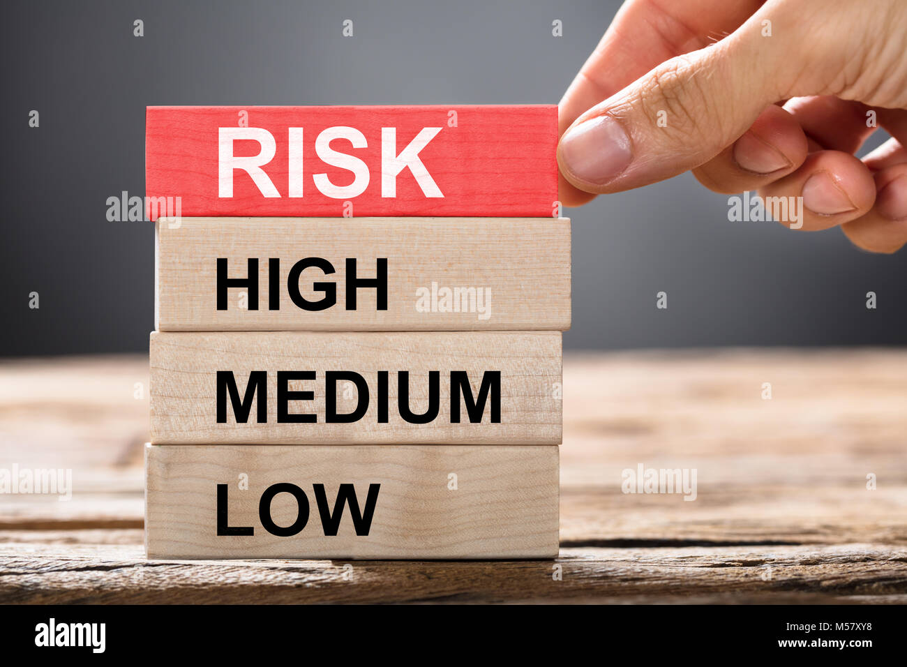 Closeup of hand building risk concept with wooden blocks on wood Stock ...
