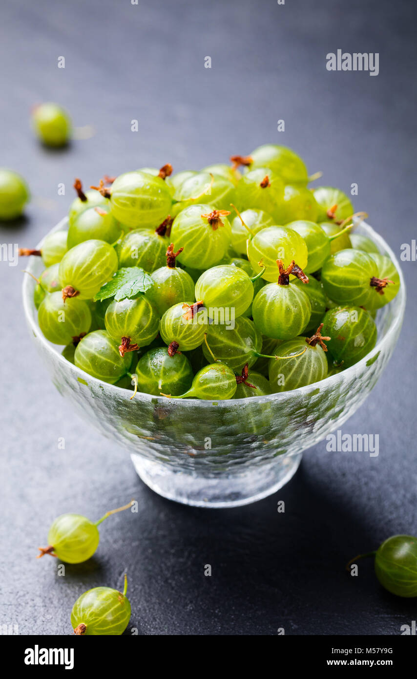 Gooseberries in glass bowl on black stone slate background Stock Photo ...
