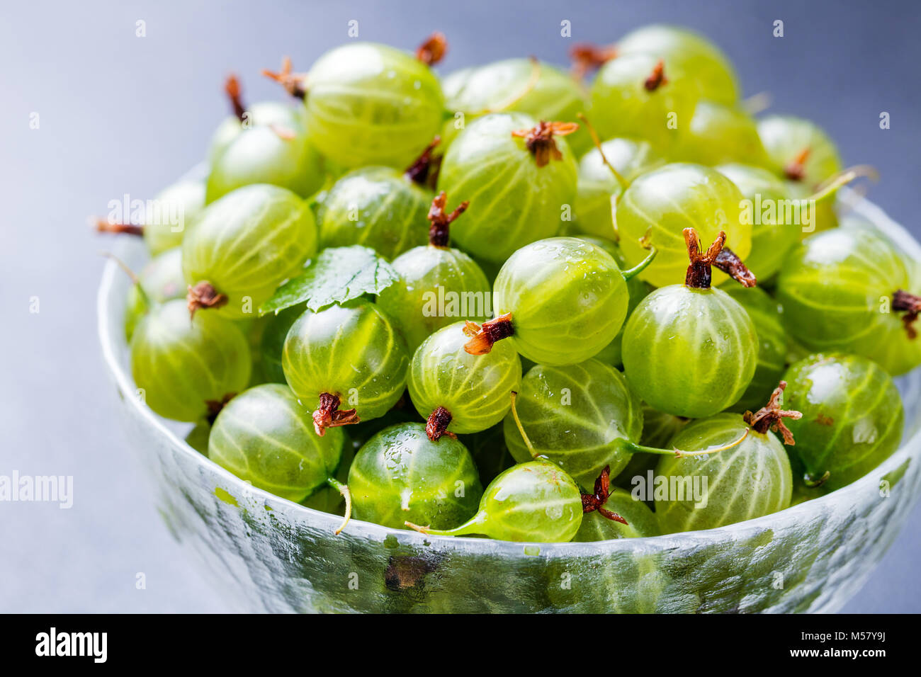 Gooseberries in glass bowl on black stone slate background Stock Photo ...