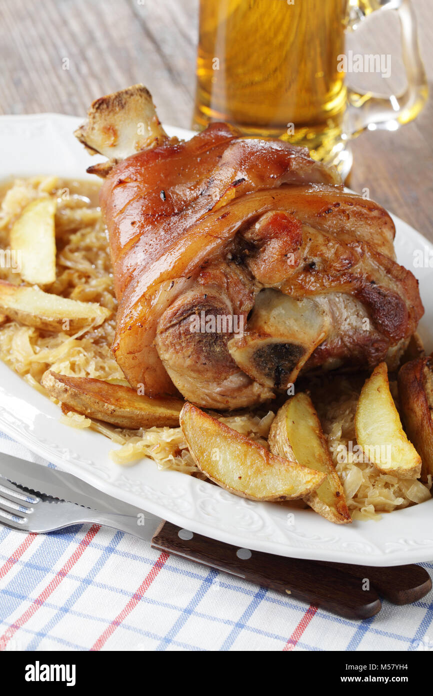 Eisbein, roasted pork knuckle with vegetables and beer Stock Photo - Alamy