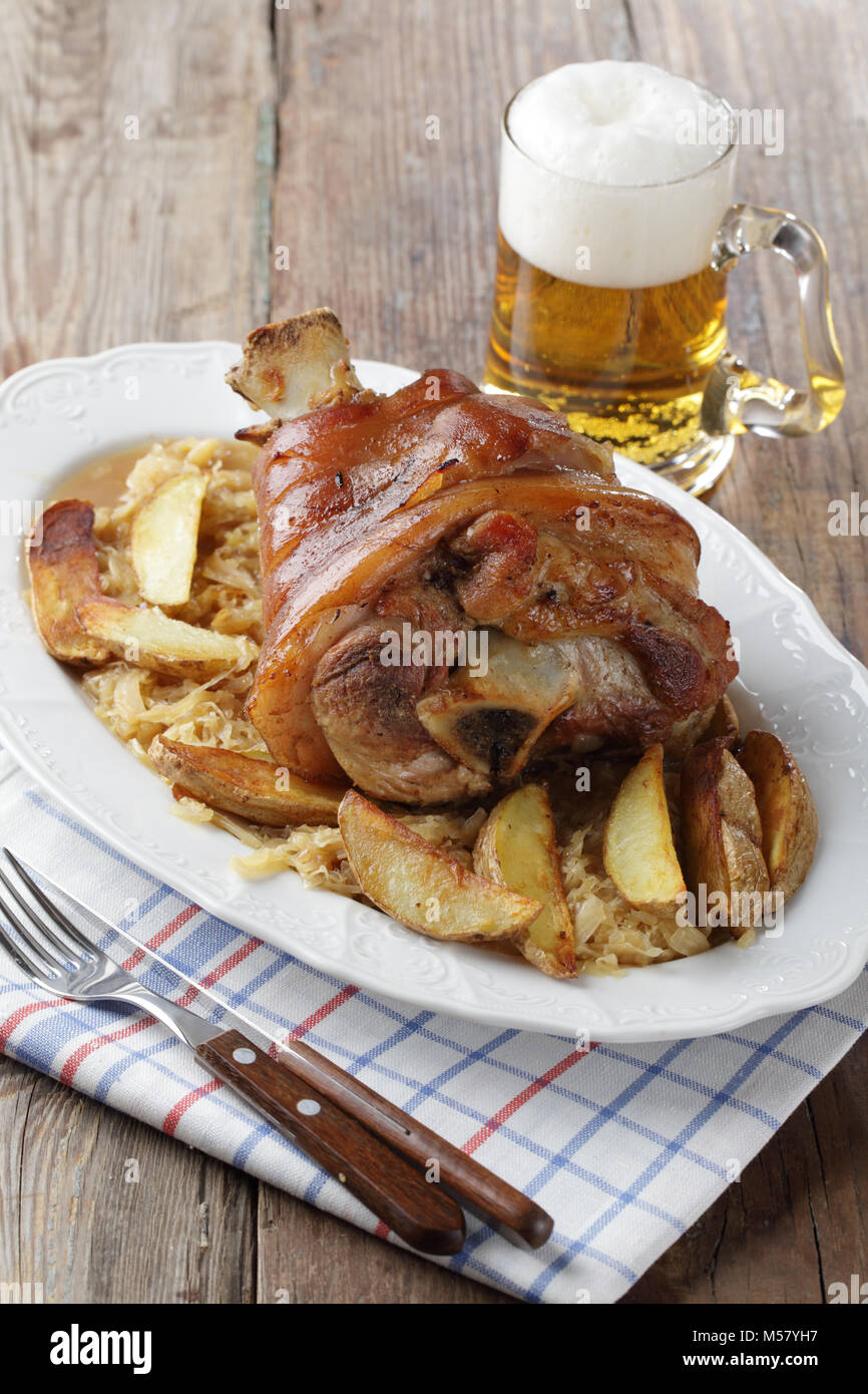 Eisbein, roasted pork knuckle with vegetables and beer Stock Photo - Alamy