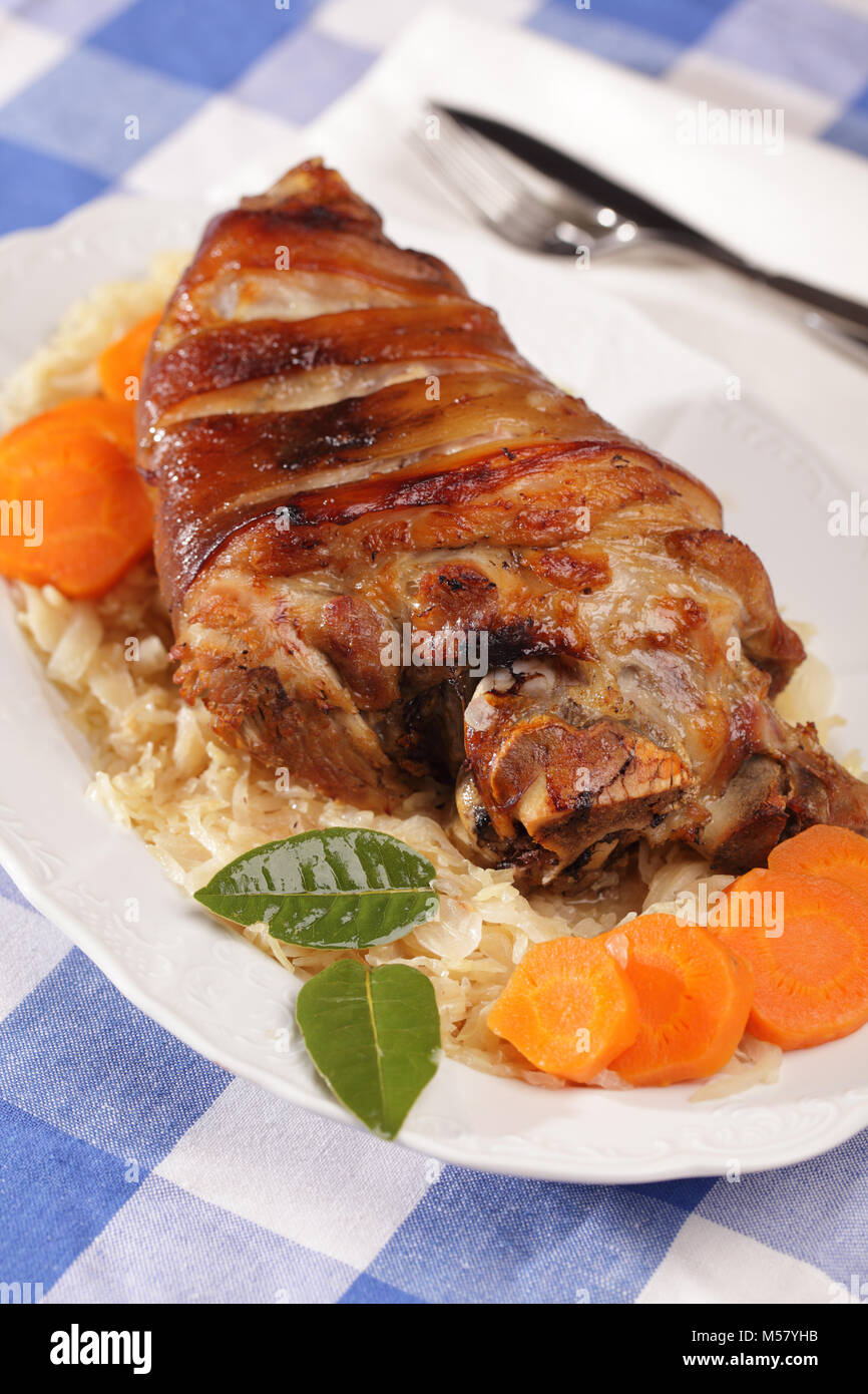 Eisbein, roasted pork knuckle with braised cabbage on a serving dish ...