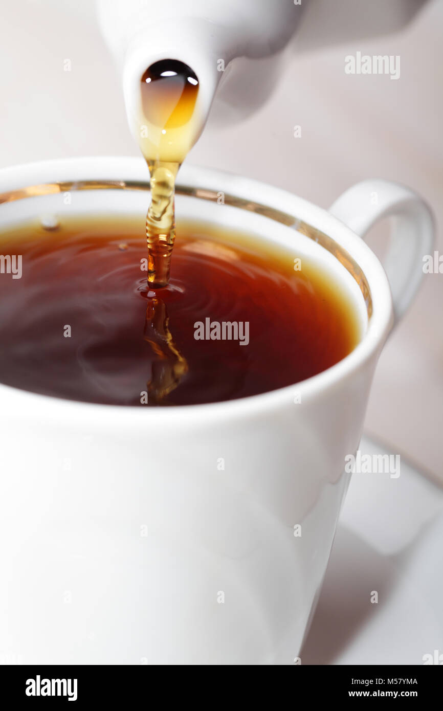 Pouring black tea in a cup Stock Photo - Alamy