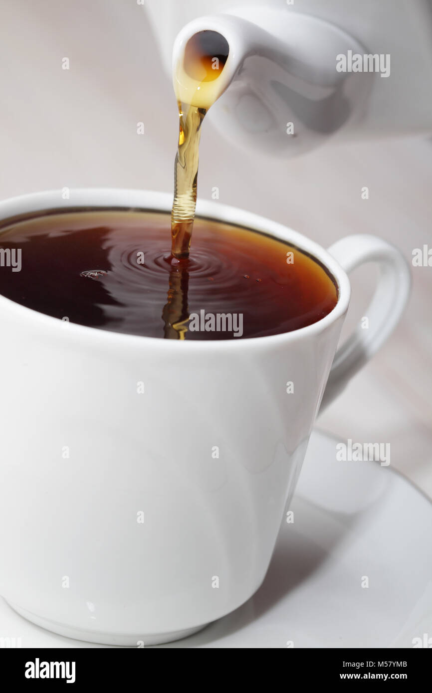 Pouring black tea in a cup Stock Photo - Alamy
