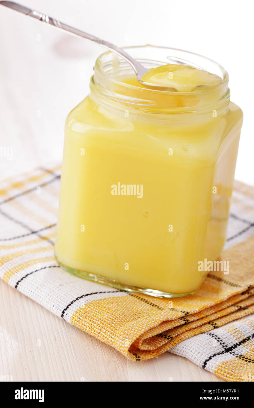 Jar with lemon curd with a spoon Stock Photo - Alamy