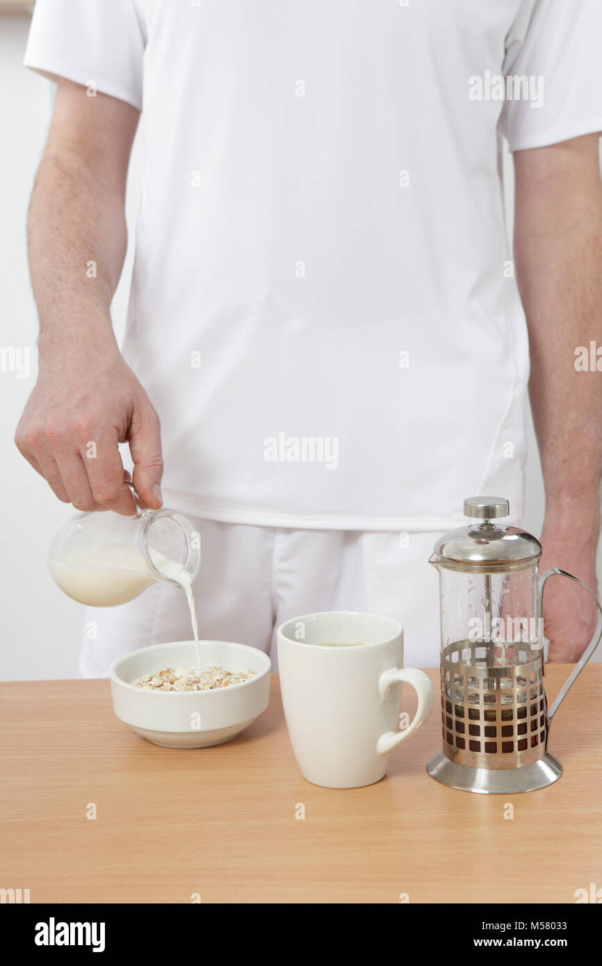 Man pouring milk in a bowl for breakfast Stock Photo - Alamy