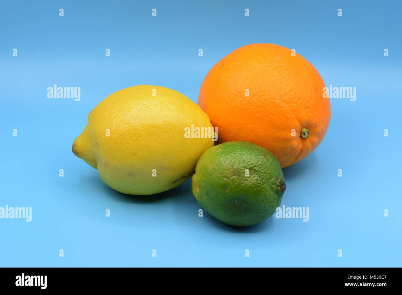 Citrus on blue with lemon, lime, and orange Stock Photo - Alamy