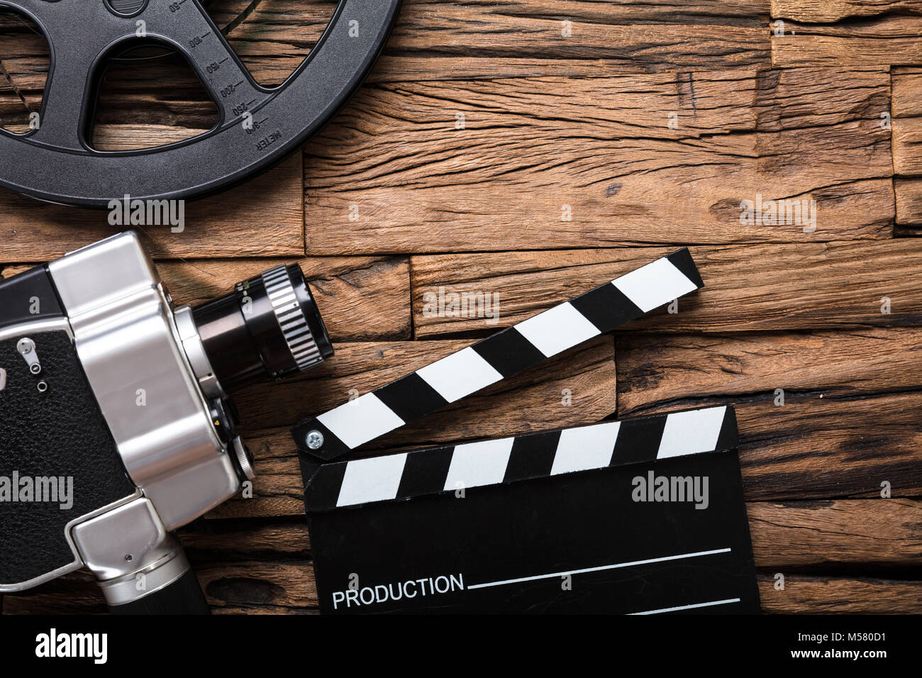 Closeup of movie camera with film reel and clapper board on wood Stock ...