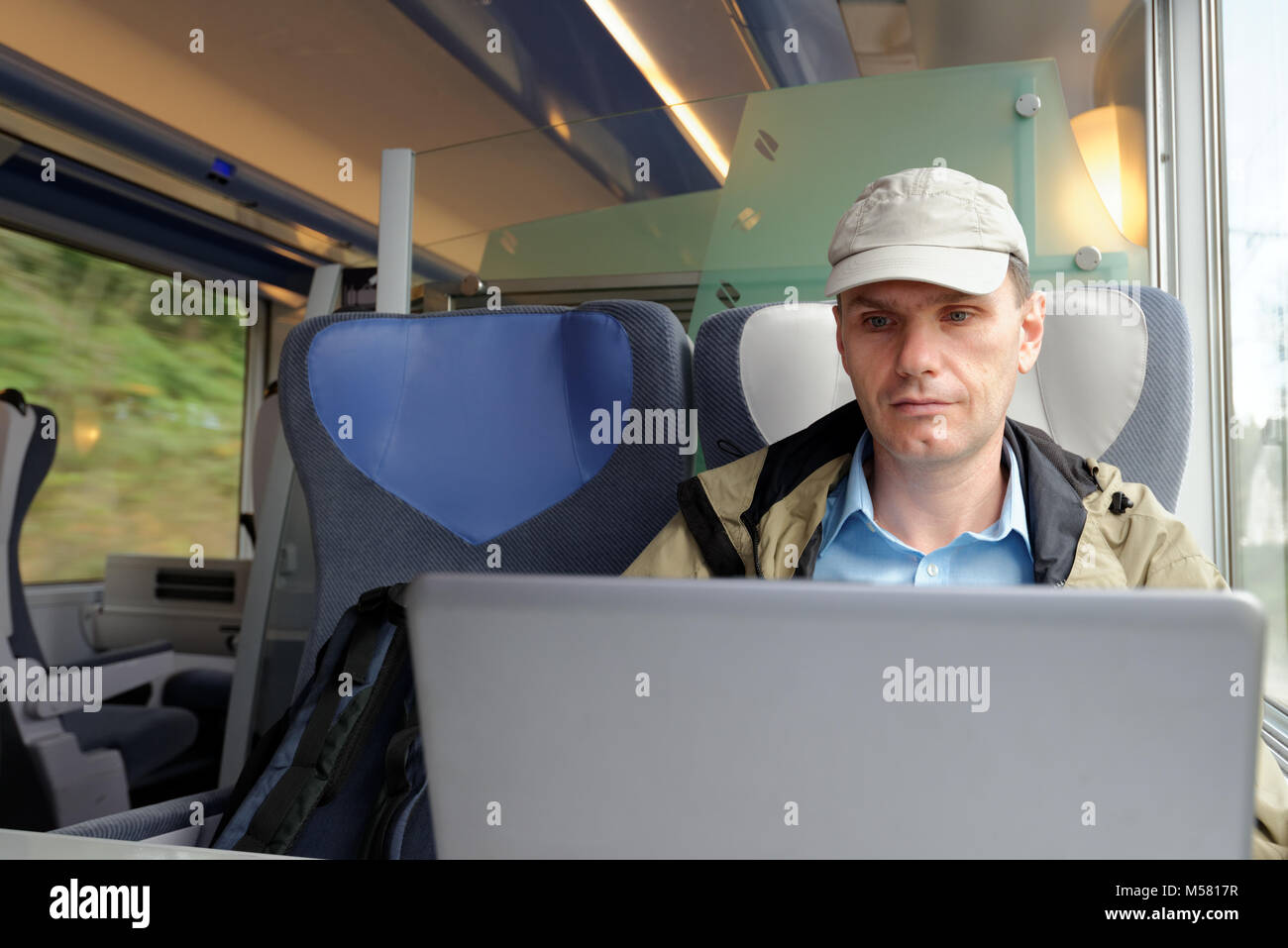 Man working with laptop in a train Stock Photo - Alamy
