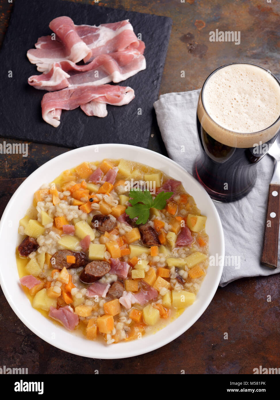 Traditional Irish dish Dublin coddle with sausages and beer on a table ...