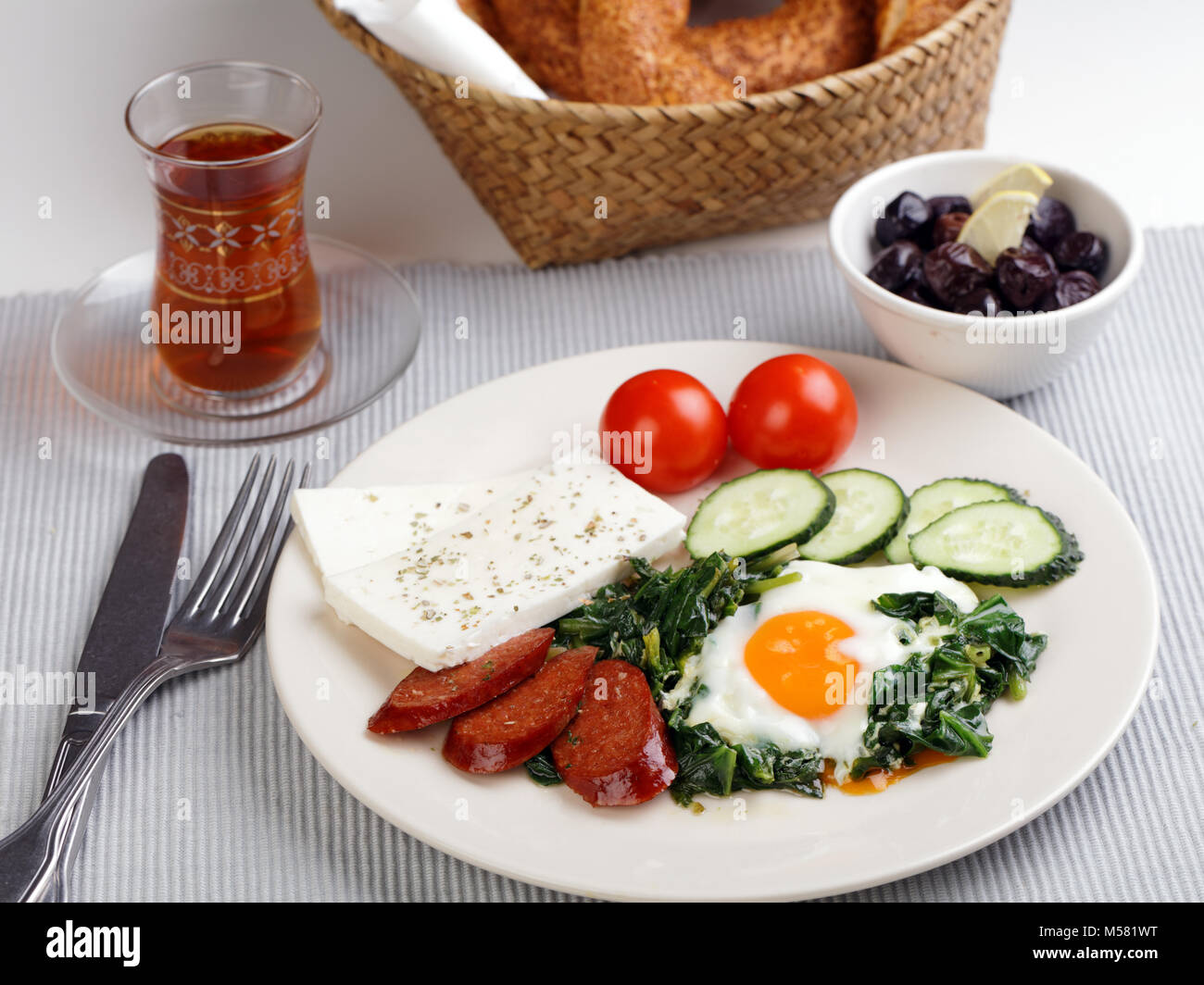Turkish breakfast with fried egg, sucuk, cheese, vegetables, simit, and ...