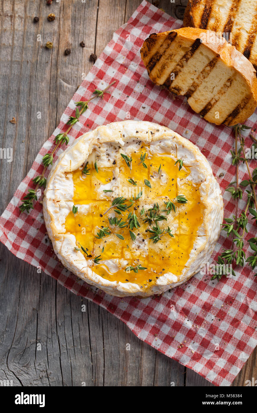 A real Camembert from France with thyme, honey and toasted bread on old ...