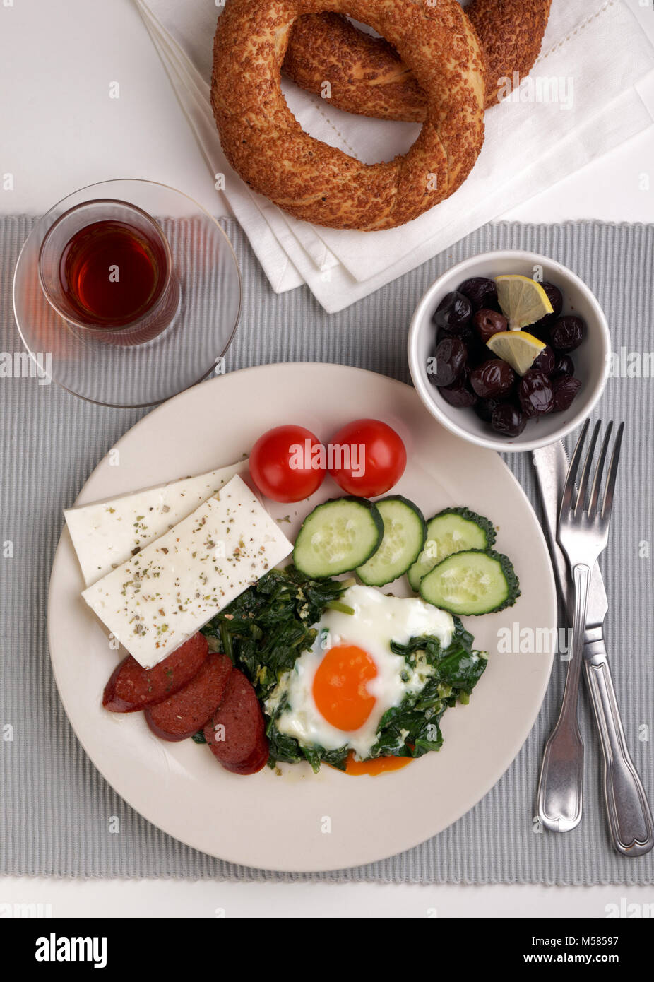 Turkish breakfast with fried egg, sucuk, cheese, vegetables, simit, and ...