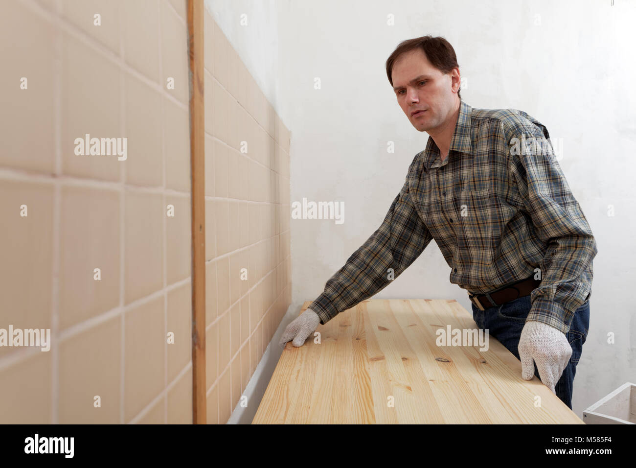 Construction worker installing a wooden countertop in a domestic ...