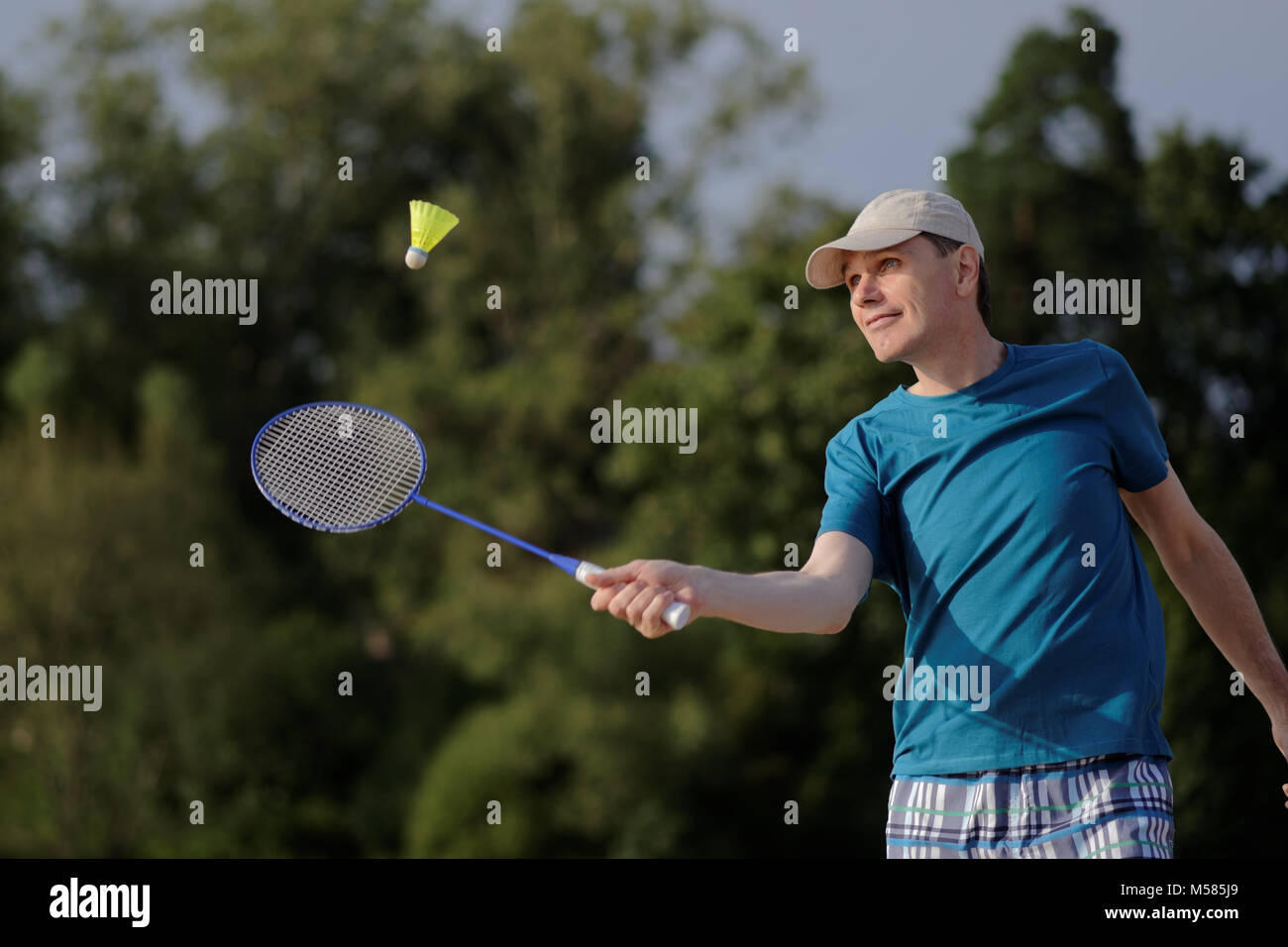 Mature man playing badminton outdoors Stock Photo - Alamy