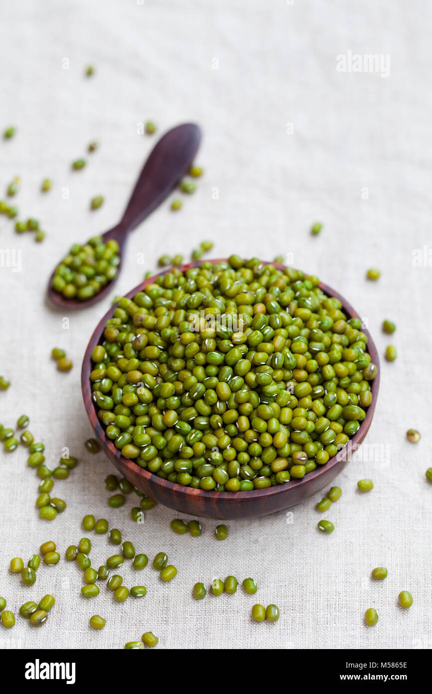 Mung bean, green moong dal in wooden bowl. White textile background ...
